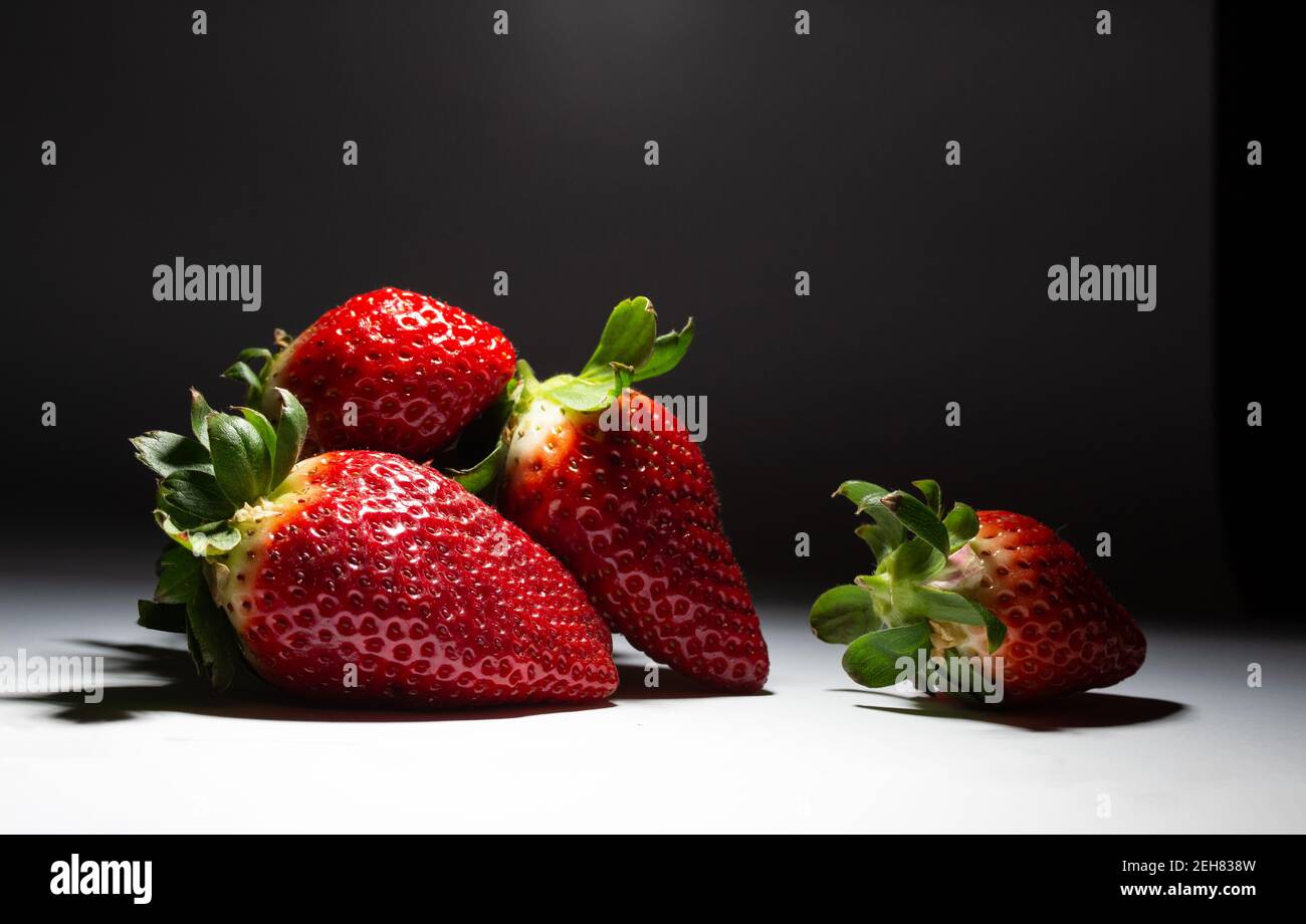 Strawberries - creative lighting - black and white background and side ...