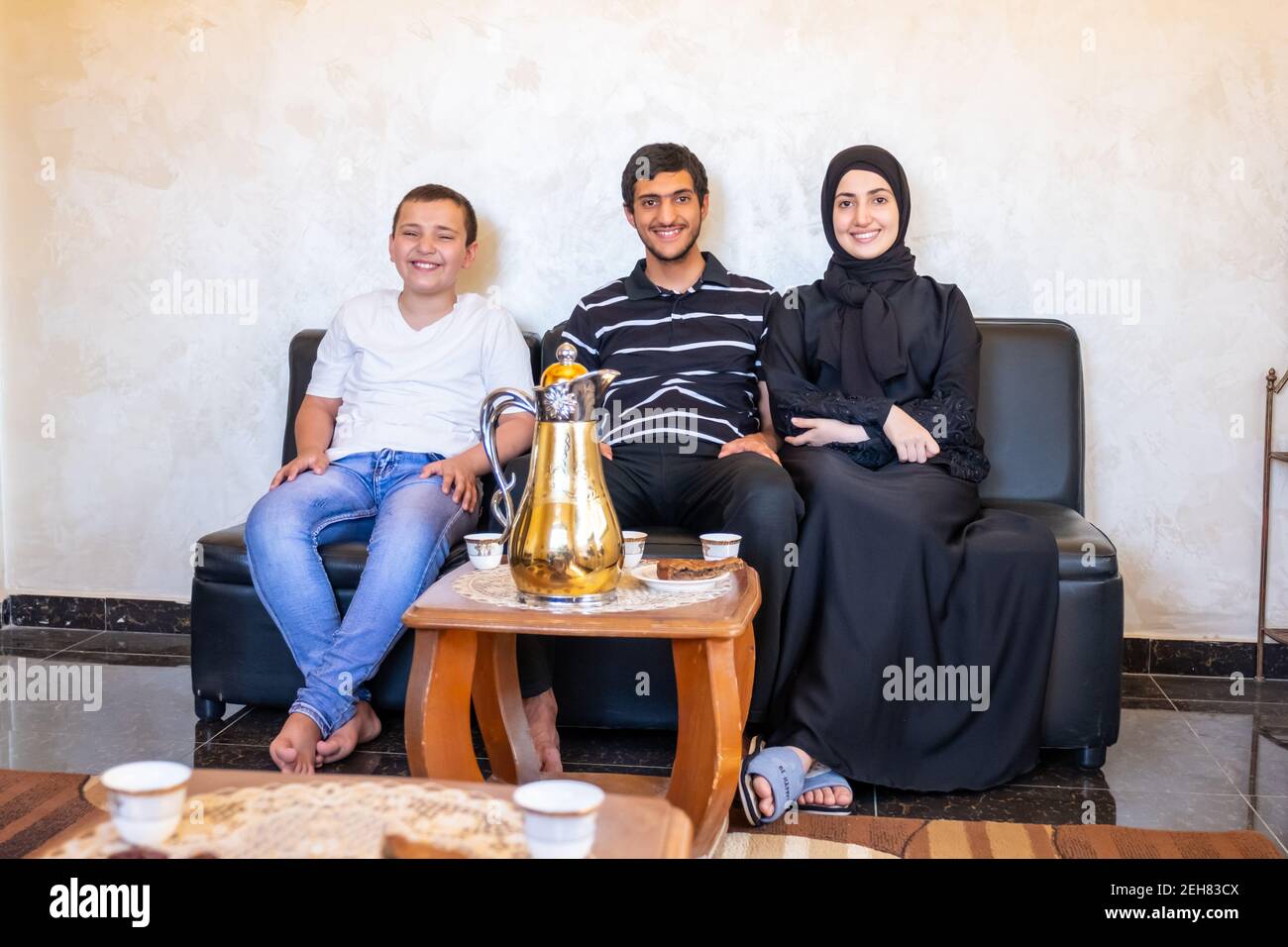 Happy Arabic family sitting together enjoying Arabic coffee and sweets ...