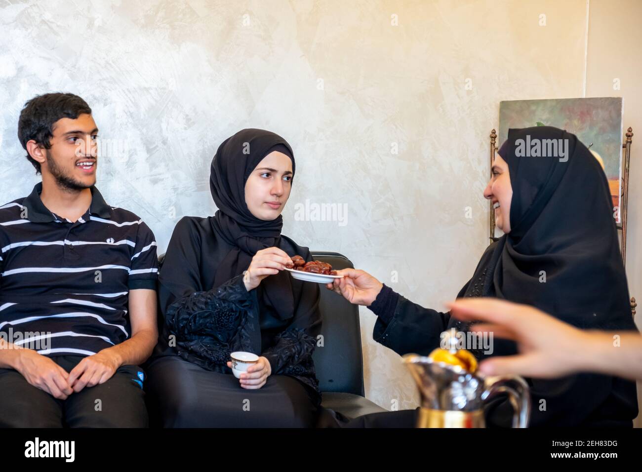 Happy Arabic family sitting together enjoying Arabic coffee and sweets ...