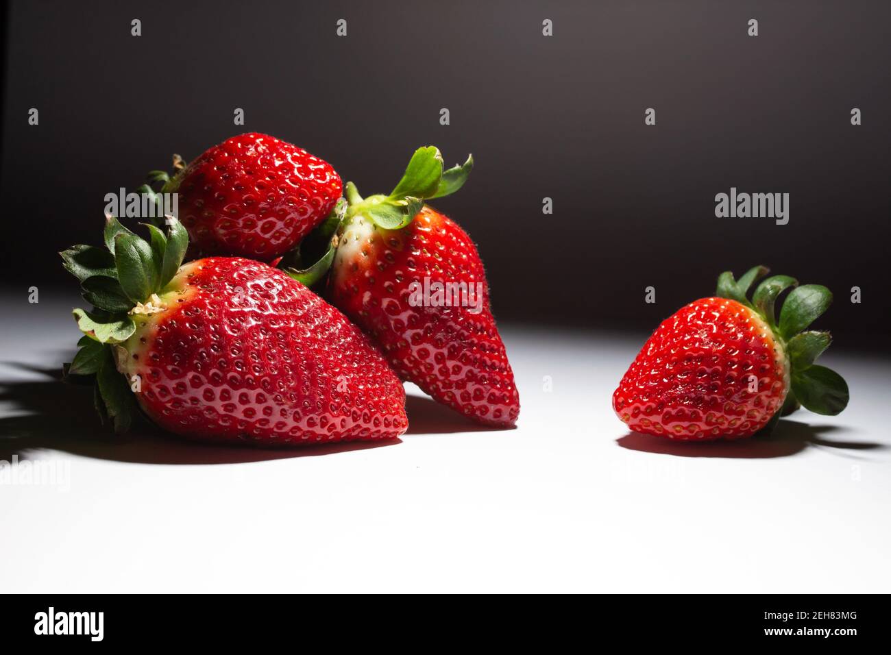 Strawberries - creative lighting - black and white background and side ...