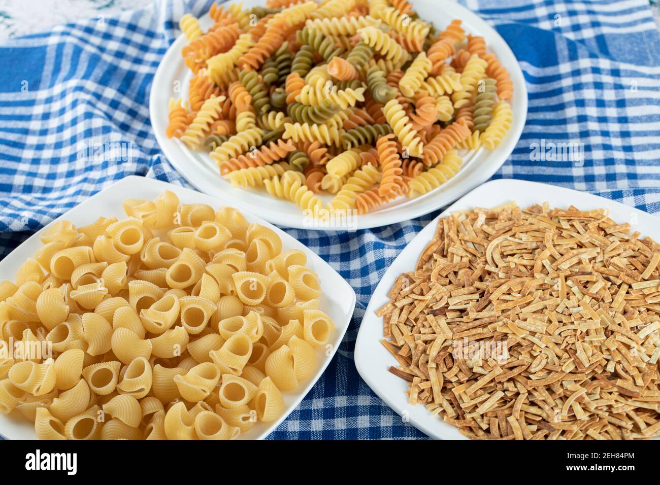 Variety of dry pasta on white plates Stock Photo - Alamy