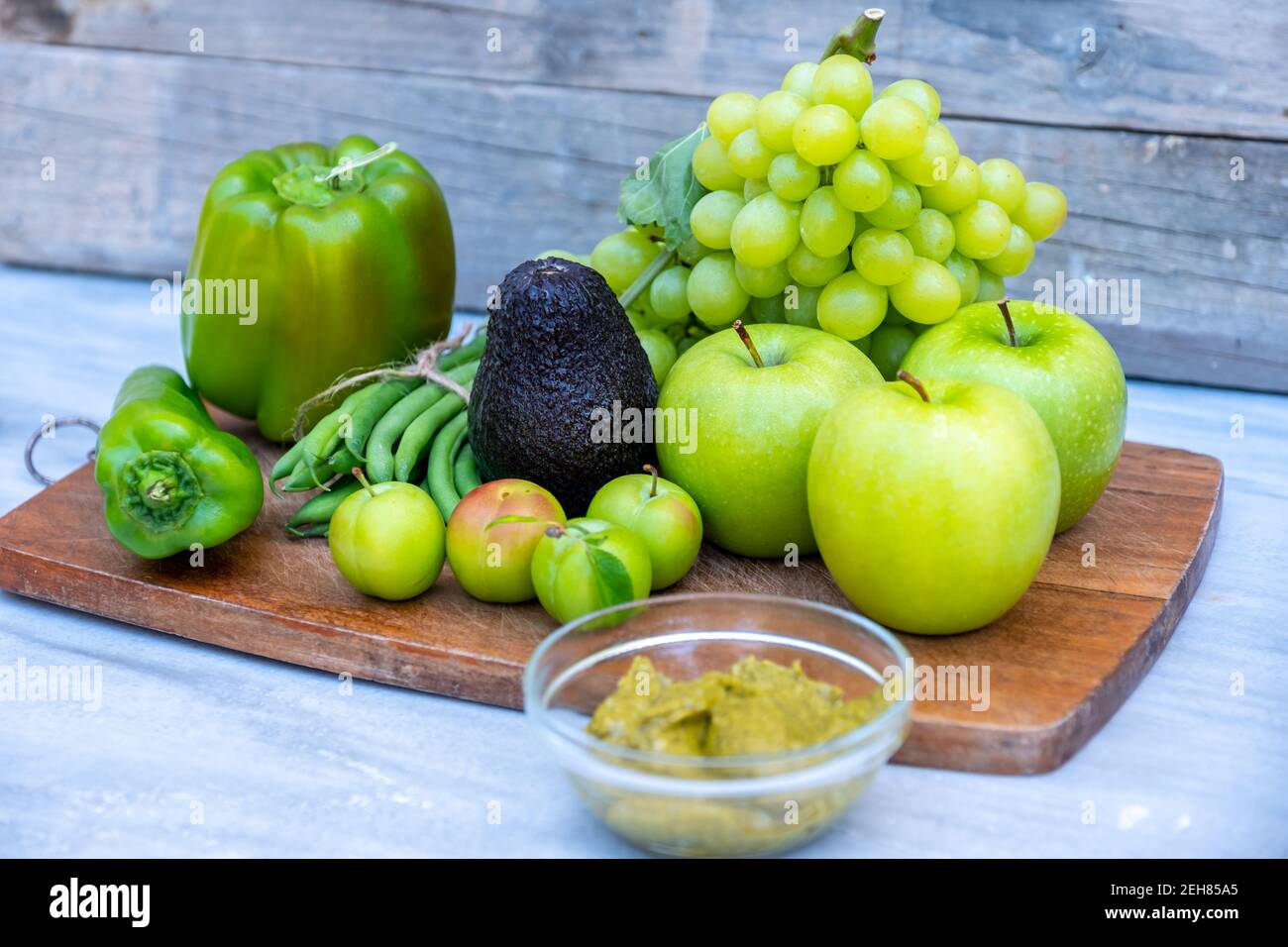 Green vegetables and fruits on a chopping board Stock Photo - Alamy