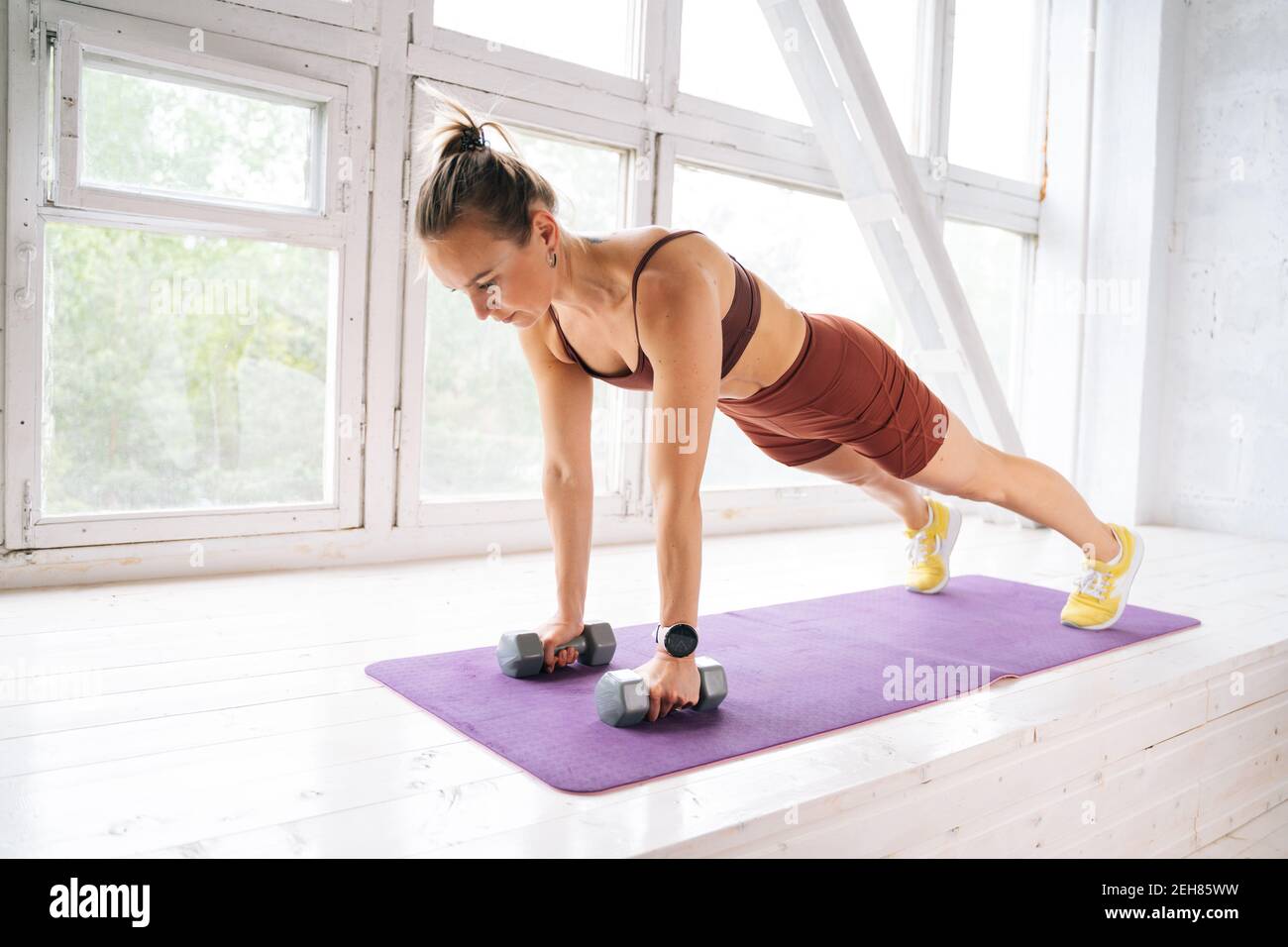 Muscular fit young woman with perfect athletic body doing push-ups ...