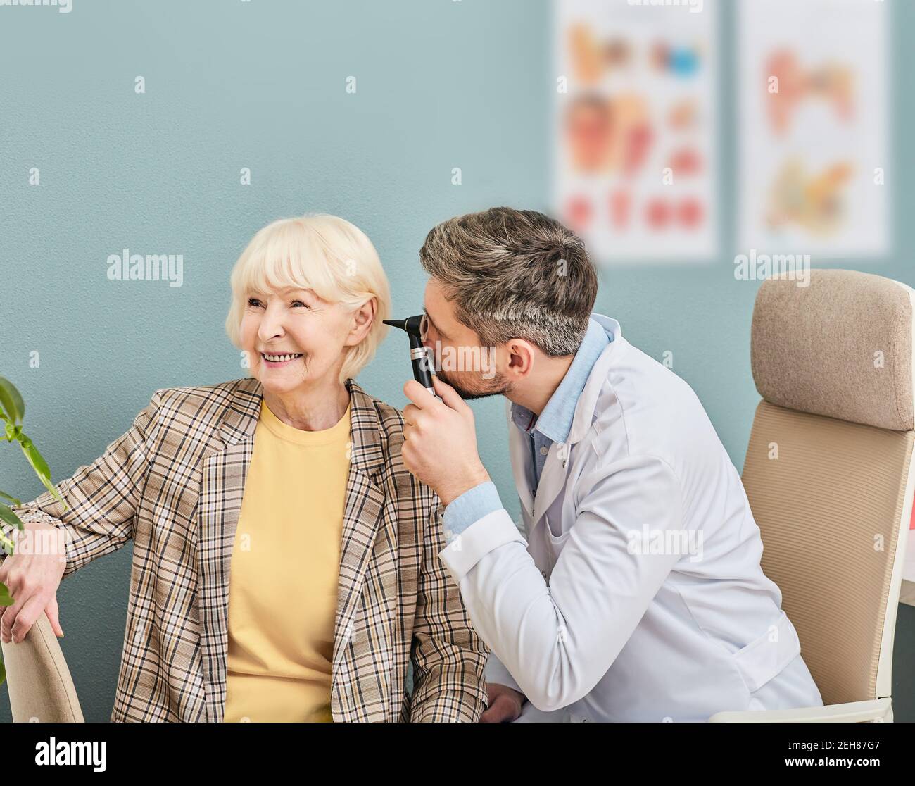 Positive elderly woman while ear examining at a hearing clinic. ENT ...