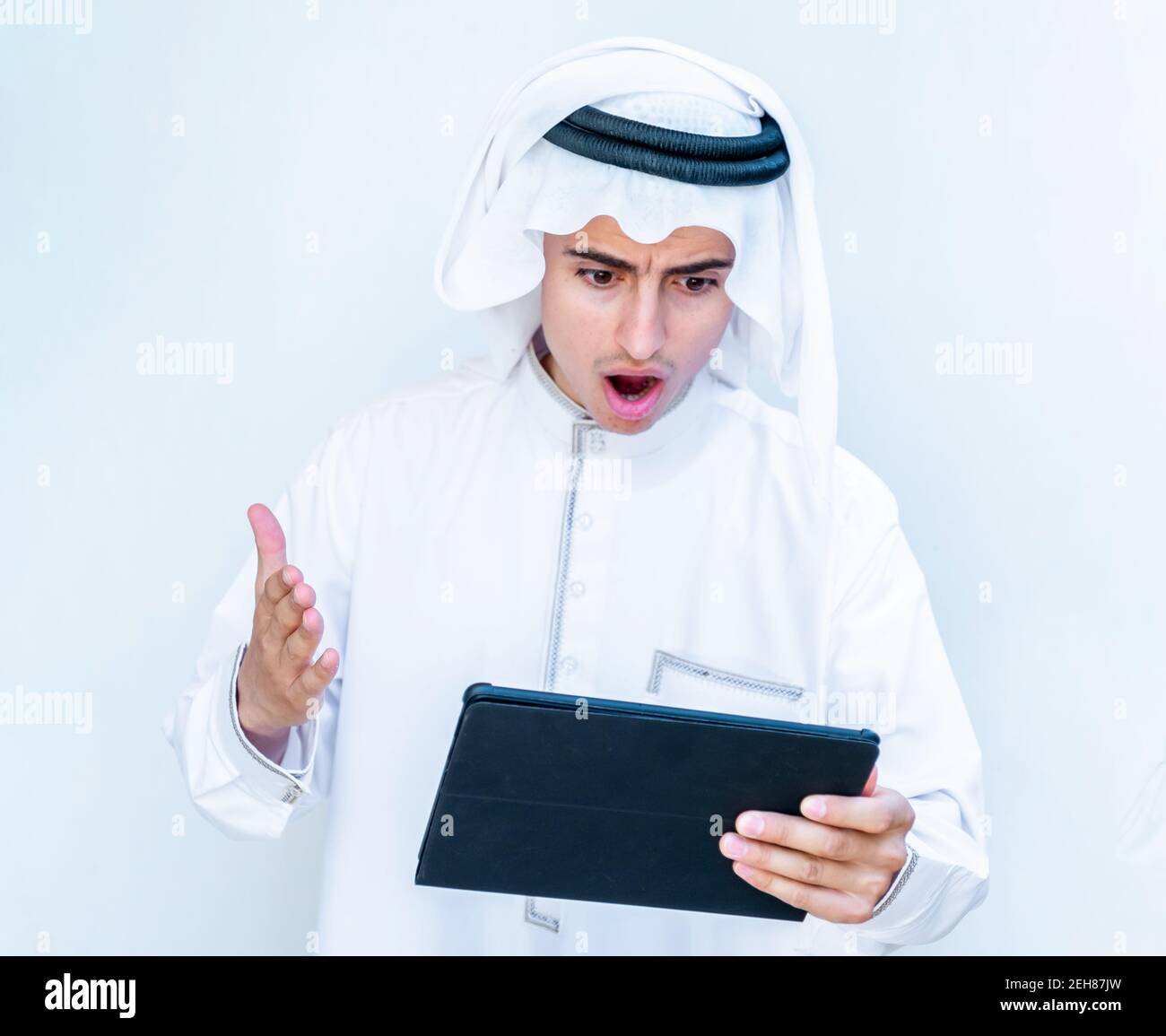 Arabic young man pointing at his tablet Stock Photo - Alamy