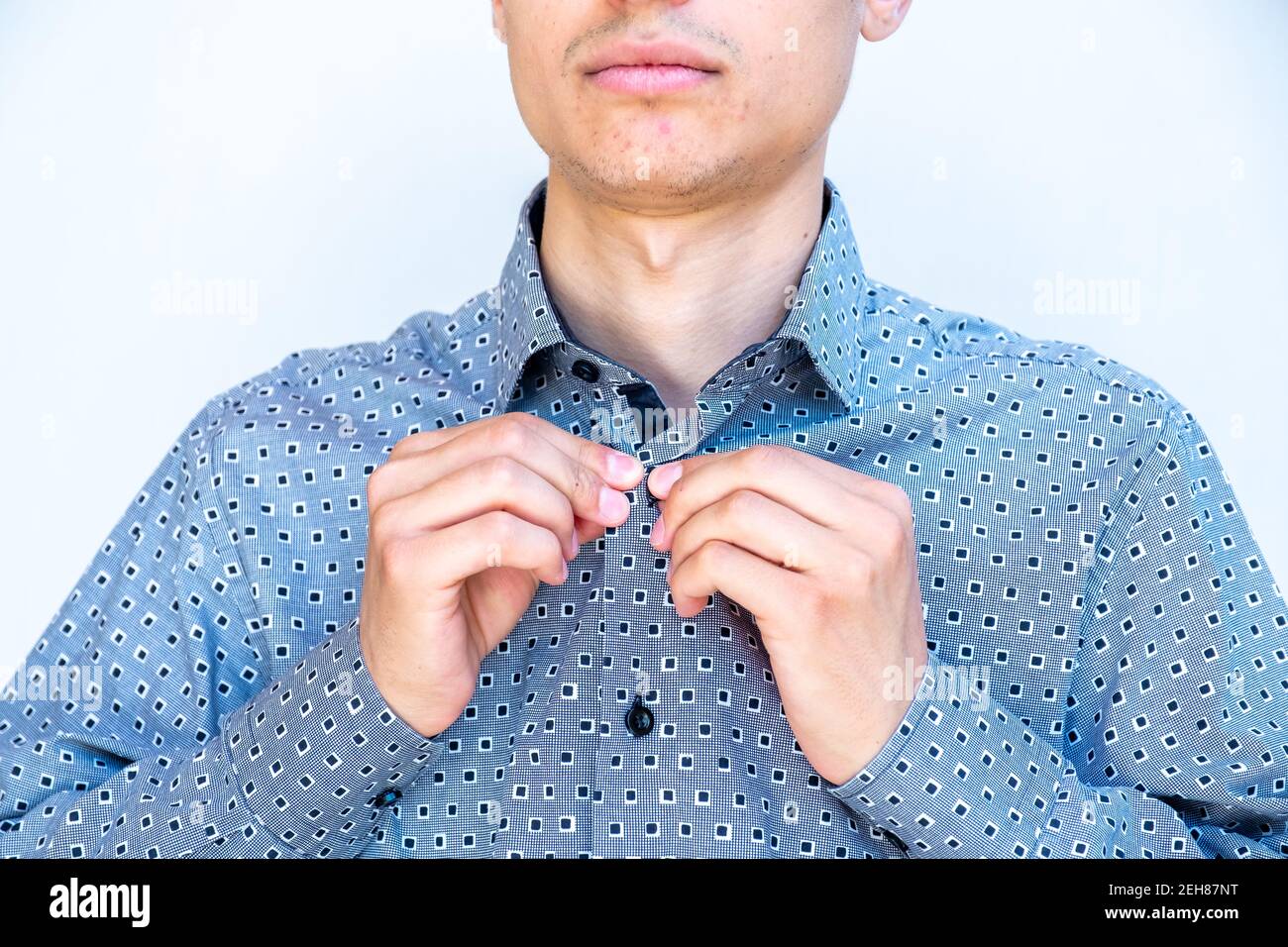 Young arabic guy doing his buttons Stock Photo - Alamy
