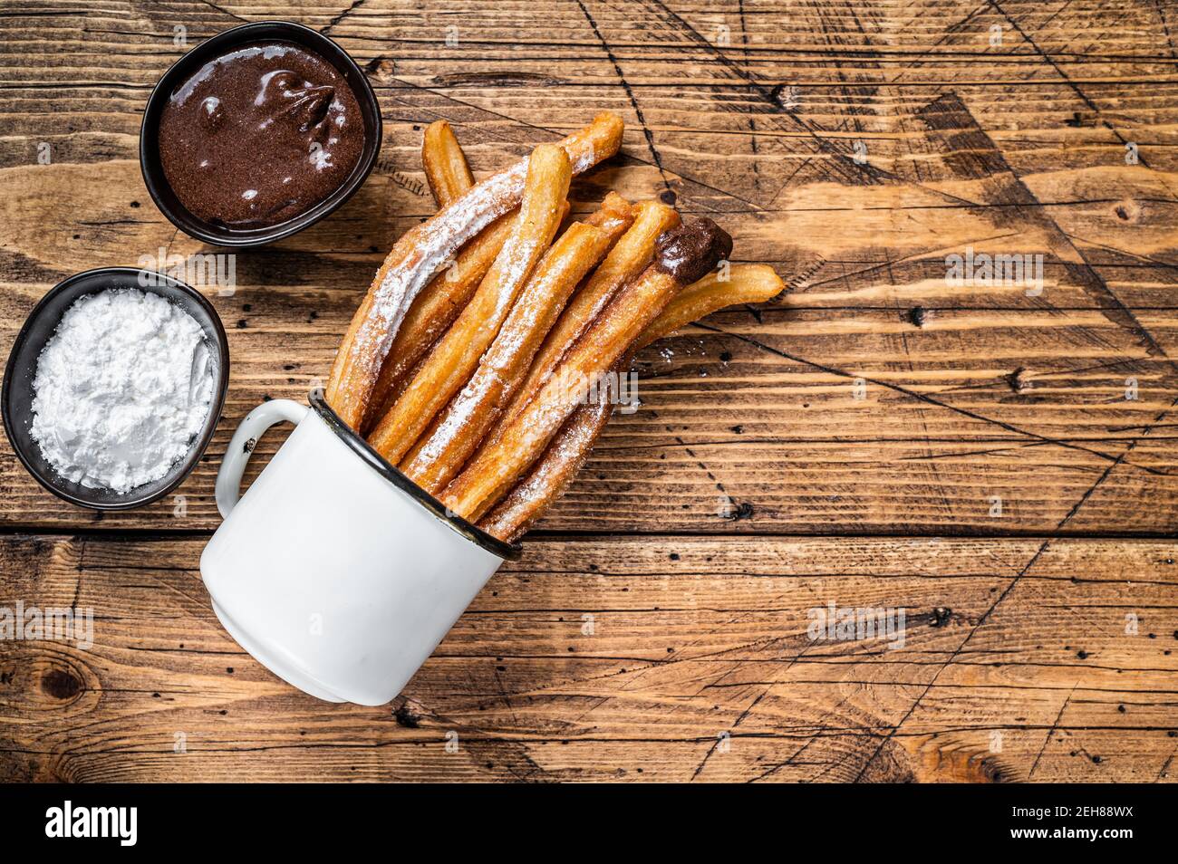 Churros with sugar and chocolate sauce. wooden background. Top view ...