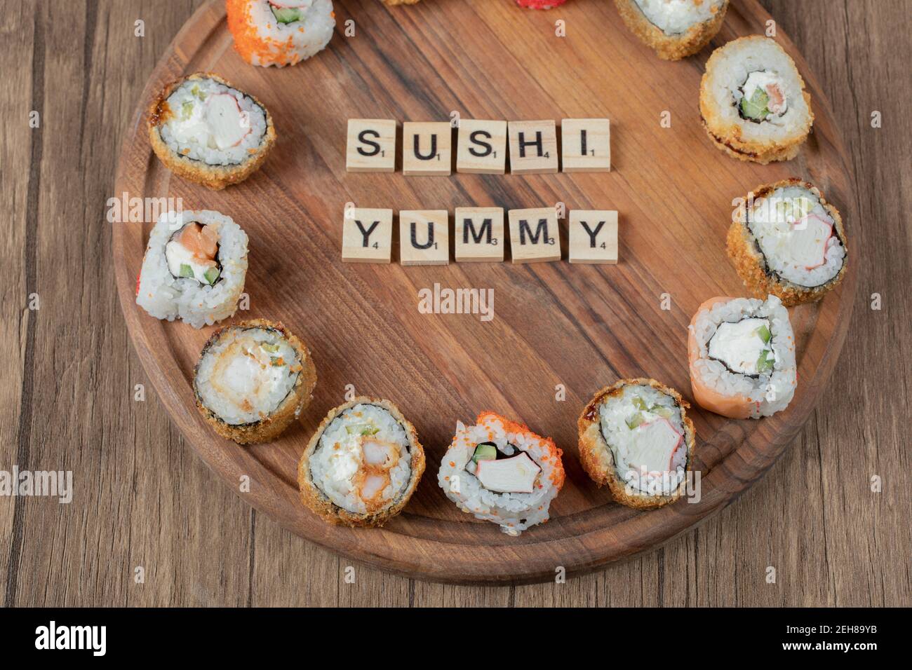 Yummy sushi writing with wooden dices around sushi rolls Stock Photo ...