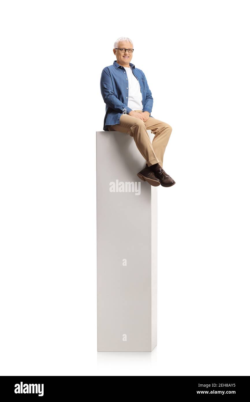 Mature man sitting on a tall white post and smiling at camera isolated ...