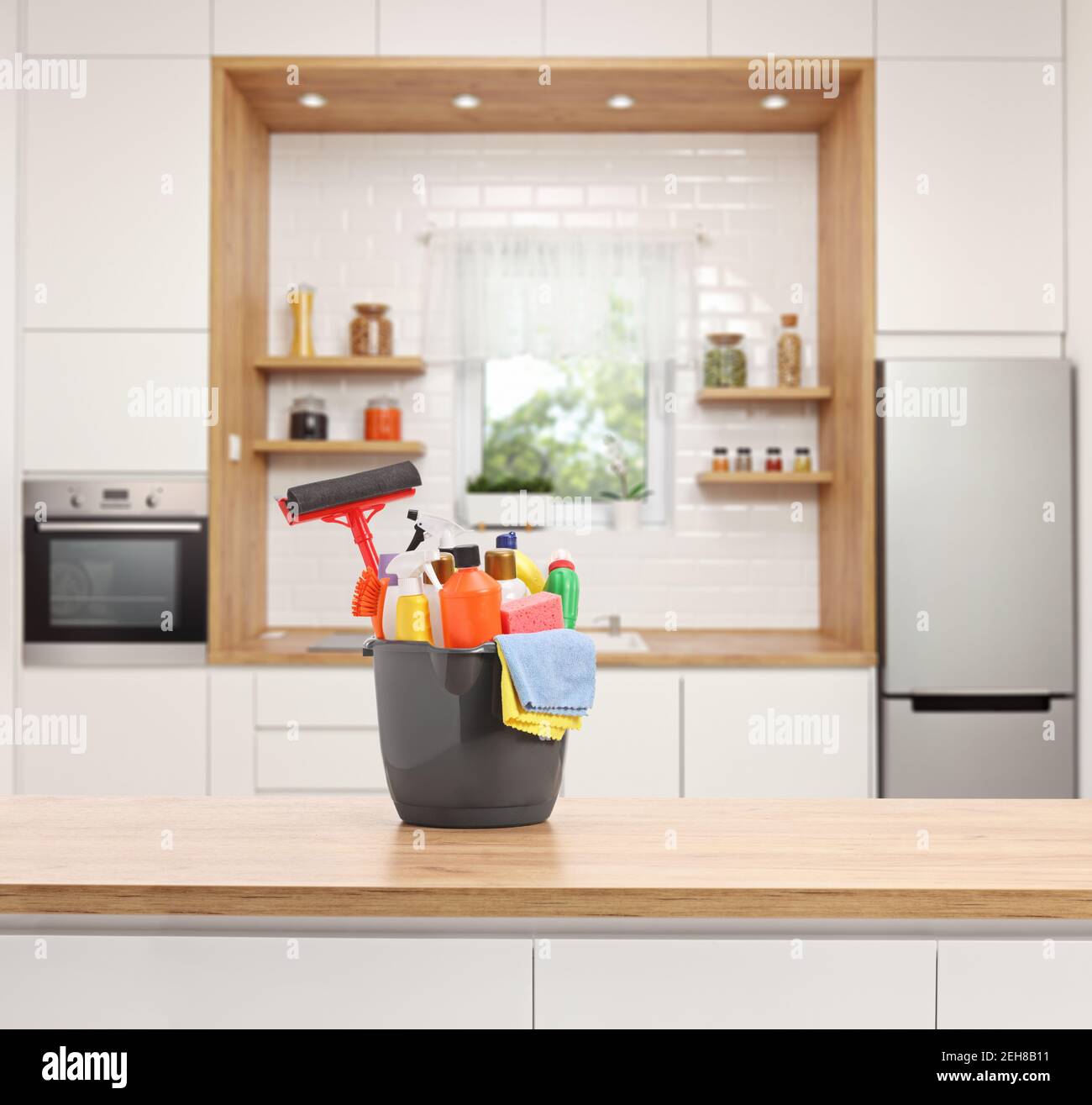 Bucket full of cleaning supplies on a wooden counter in a modern ...