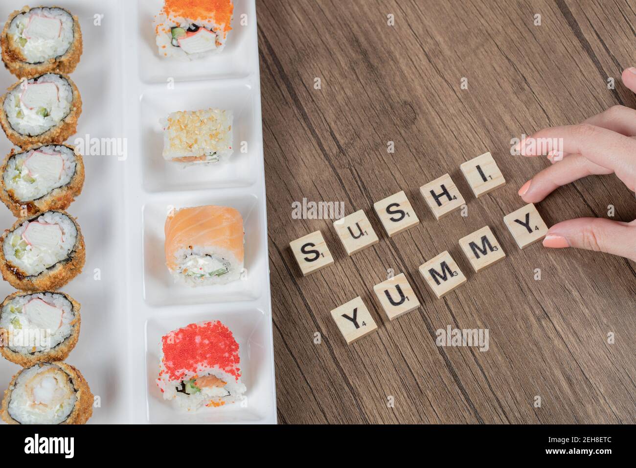 Sushi yummy writing with wooden dices around sushi rolls Stock Photo ...
