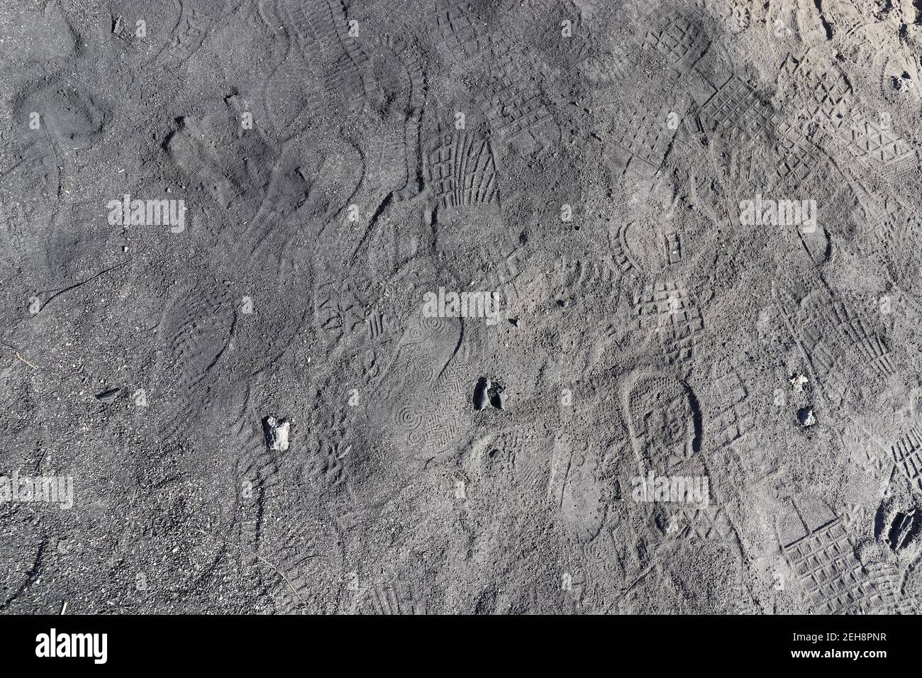 footprints on the black ground, steps on the ground Stock Photo - Alamy