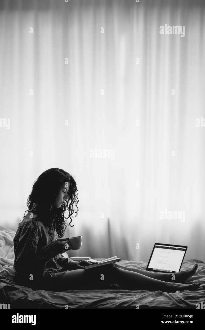 pretty brunette woman in morning bed with books and coffee Stock Photo ...