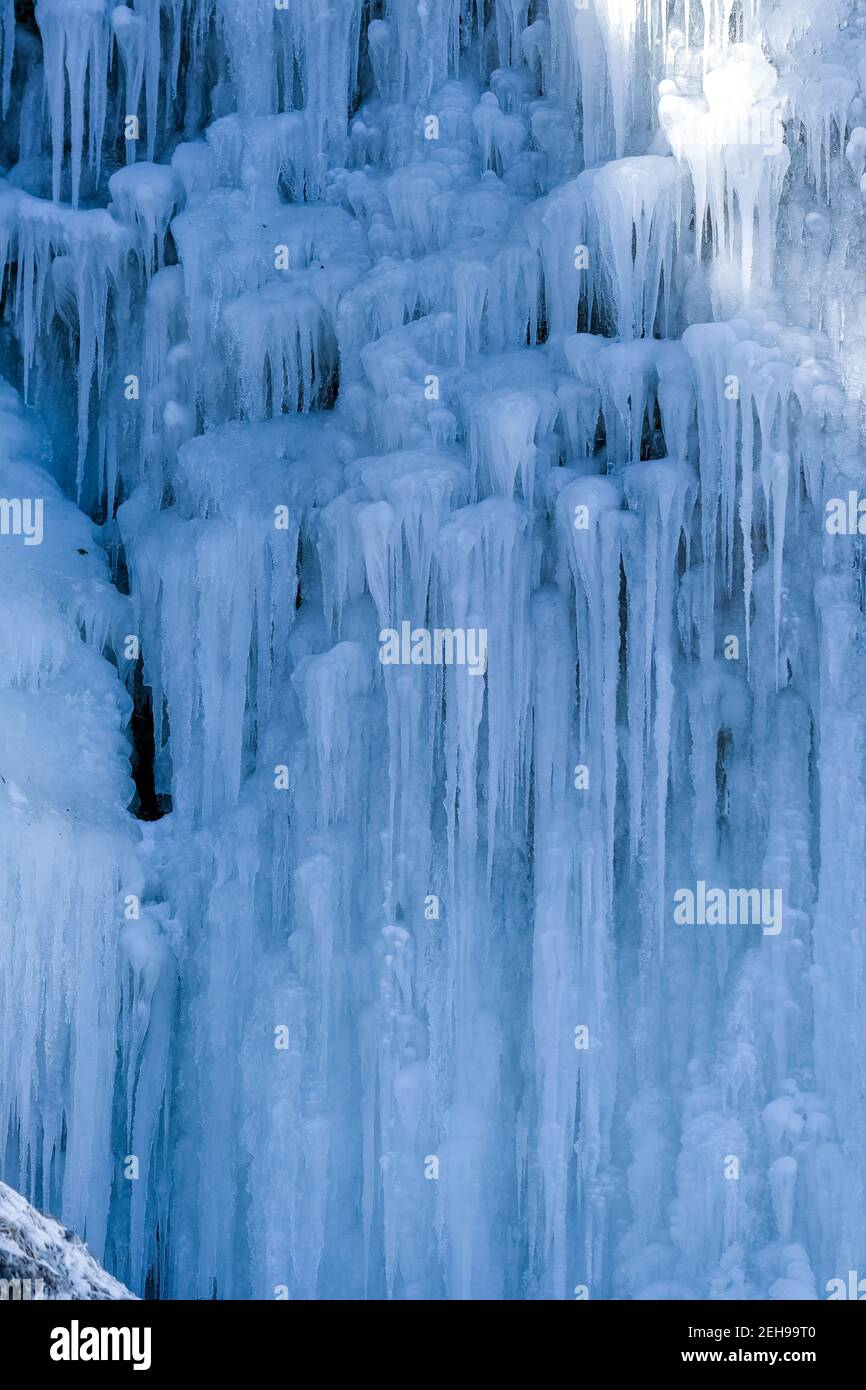 Beautiful ice structures of a frozen waterfall, pretty icicles forming ...