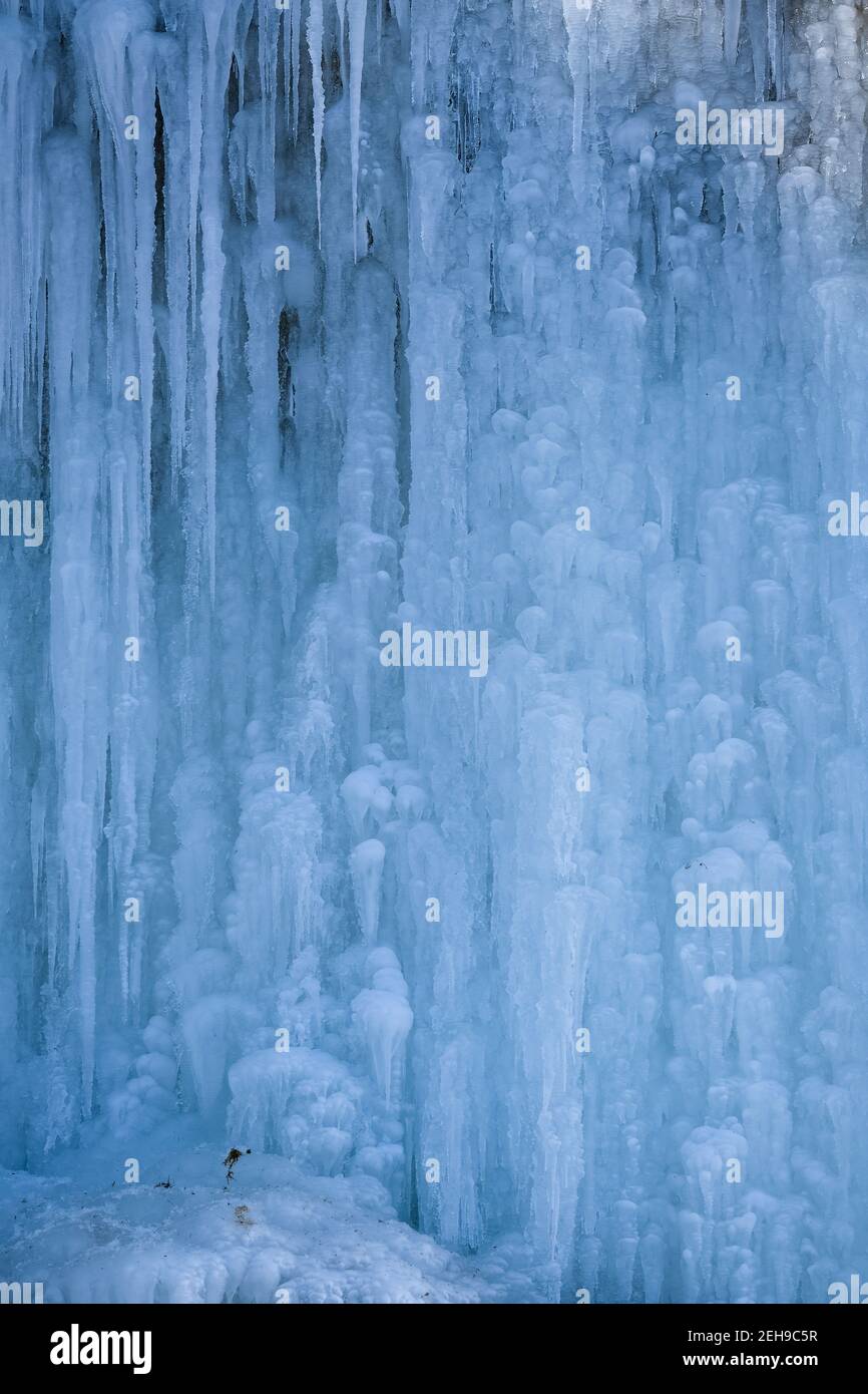 Beautiful ice structures of a frozen waterfall, pretty icicles forming ...