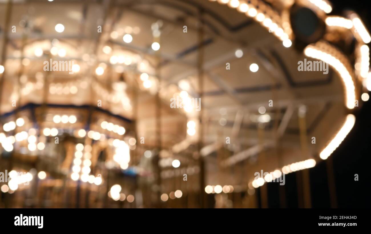 Illuminated blurred merry go round in park. Brightly illuminated ...