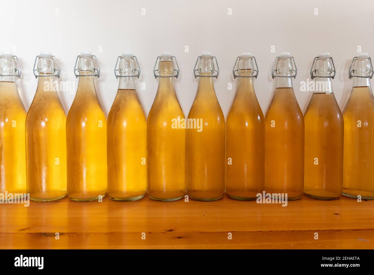 Close up of a row of flip top bottles of home made cider covered in ...