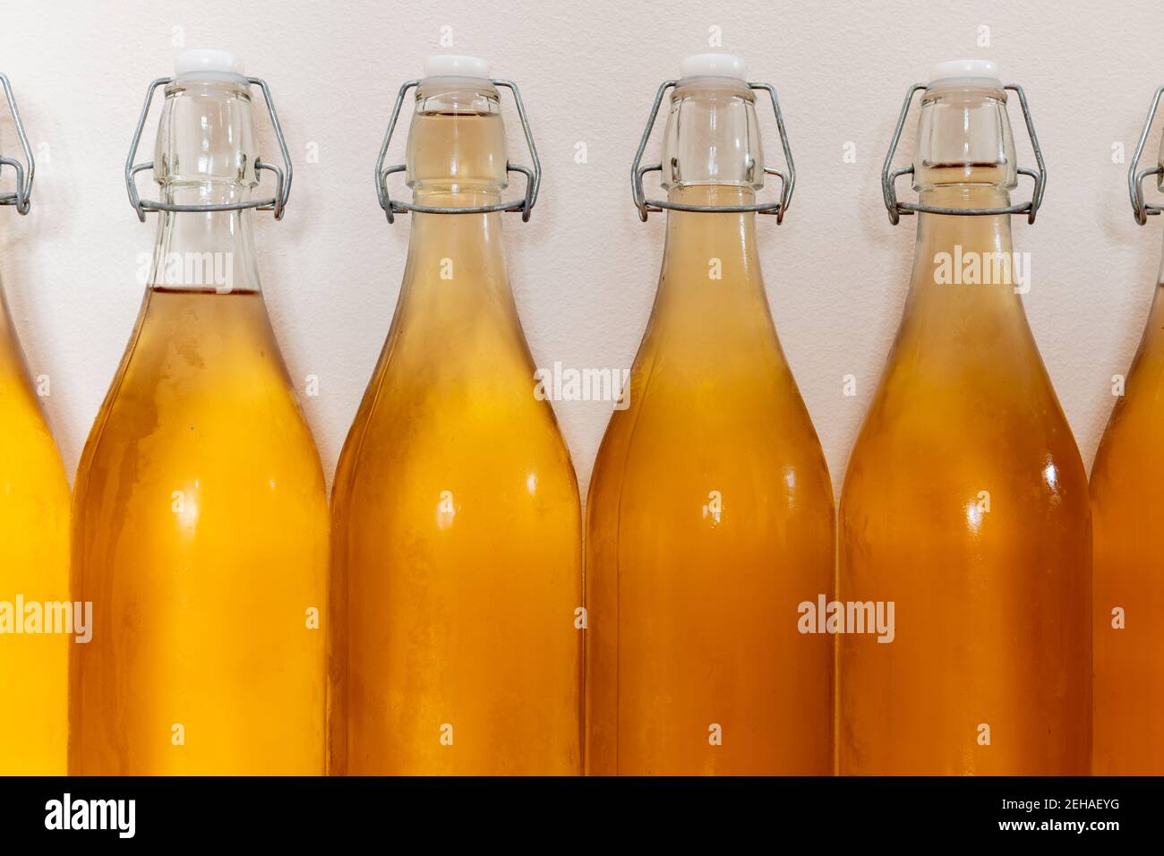 Close up of a row of flip top bottles of home made cider covered in ...