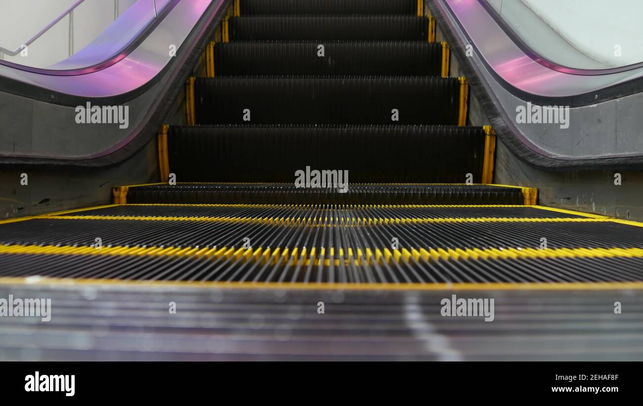 Low angle looped perspective view of modern escalator stairs. Automated ...