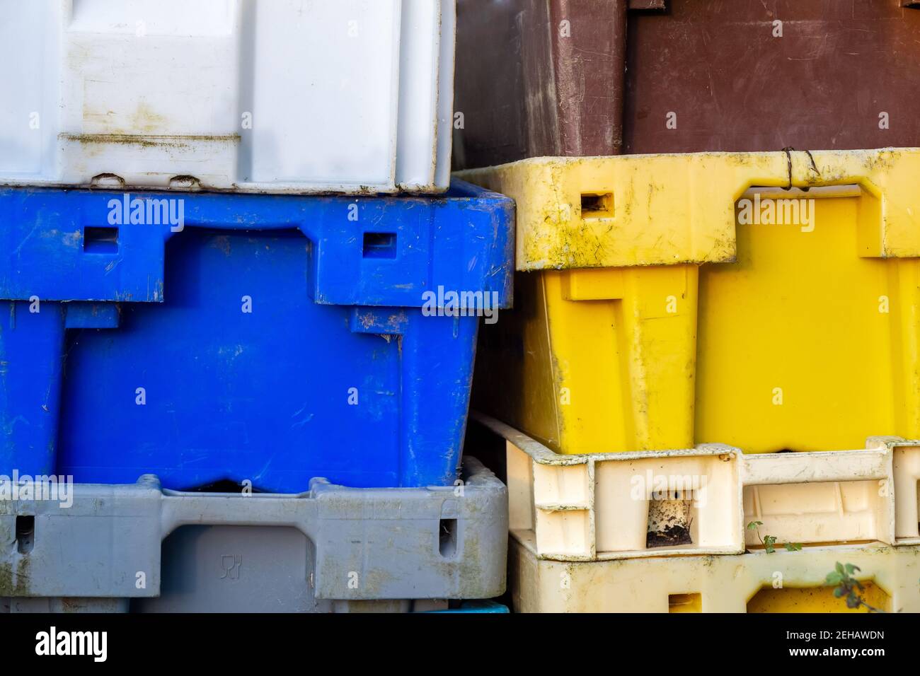 Multi colored plastic cargo crates stacked up on top of each other ...