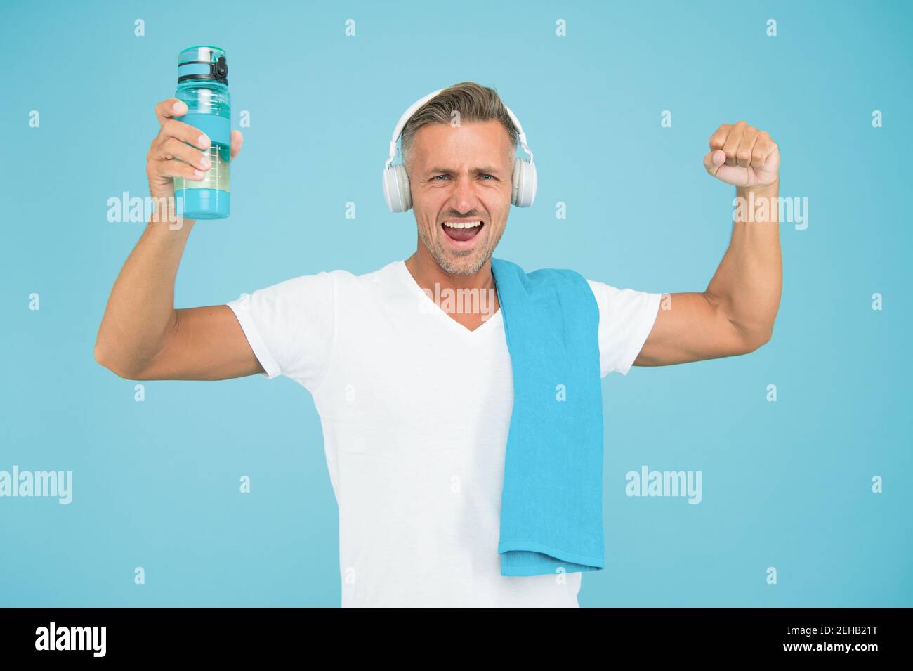 Staying hydrated staying healthy. Healthy and strong man on blue ...
