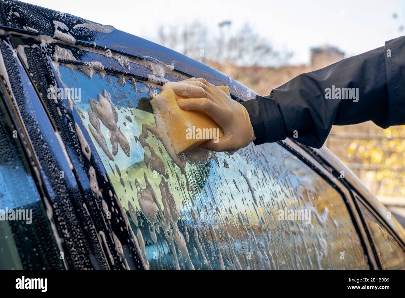 Car window washing with a soapy sponge.Male hand holding soapy sponge ...