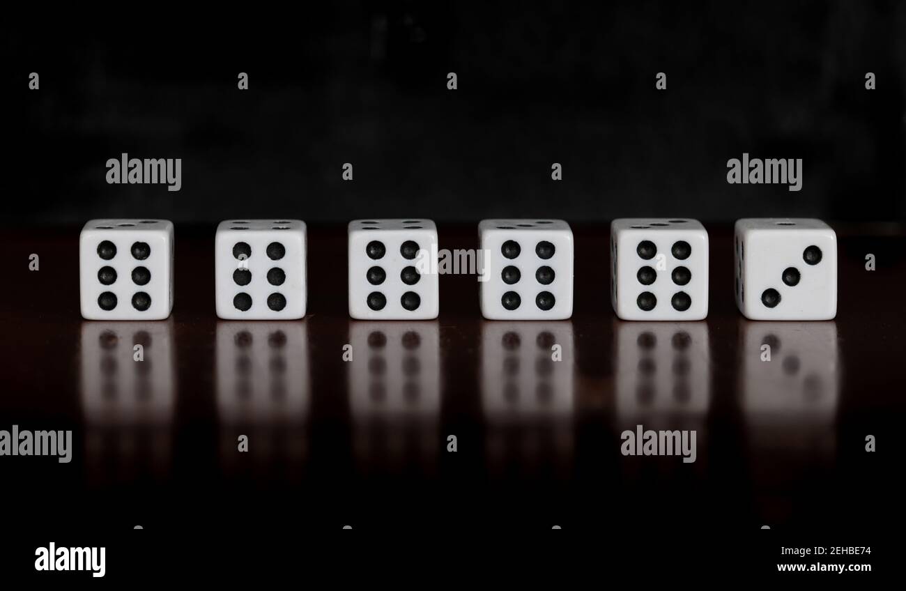 Six dice on a table with reflection and black background, five dice ...
