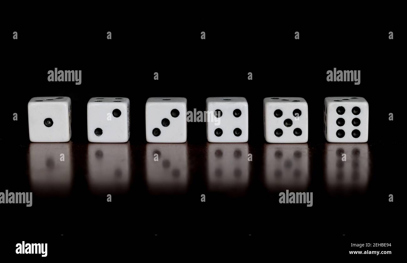 Six dice showing one through six on a table with reflection and black ...