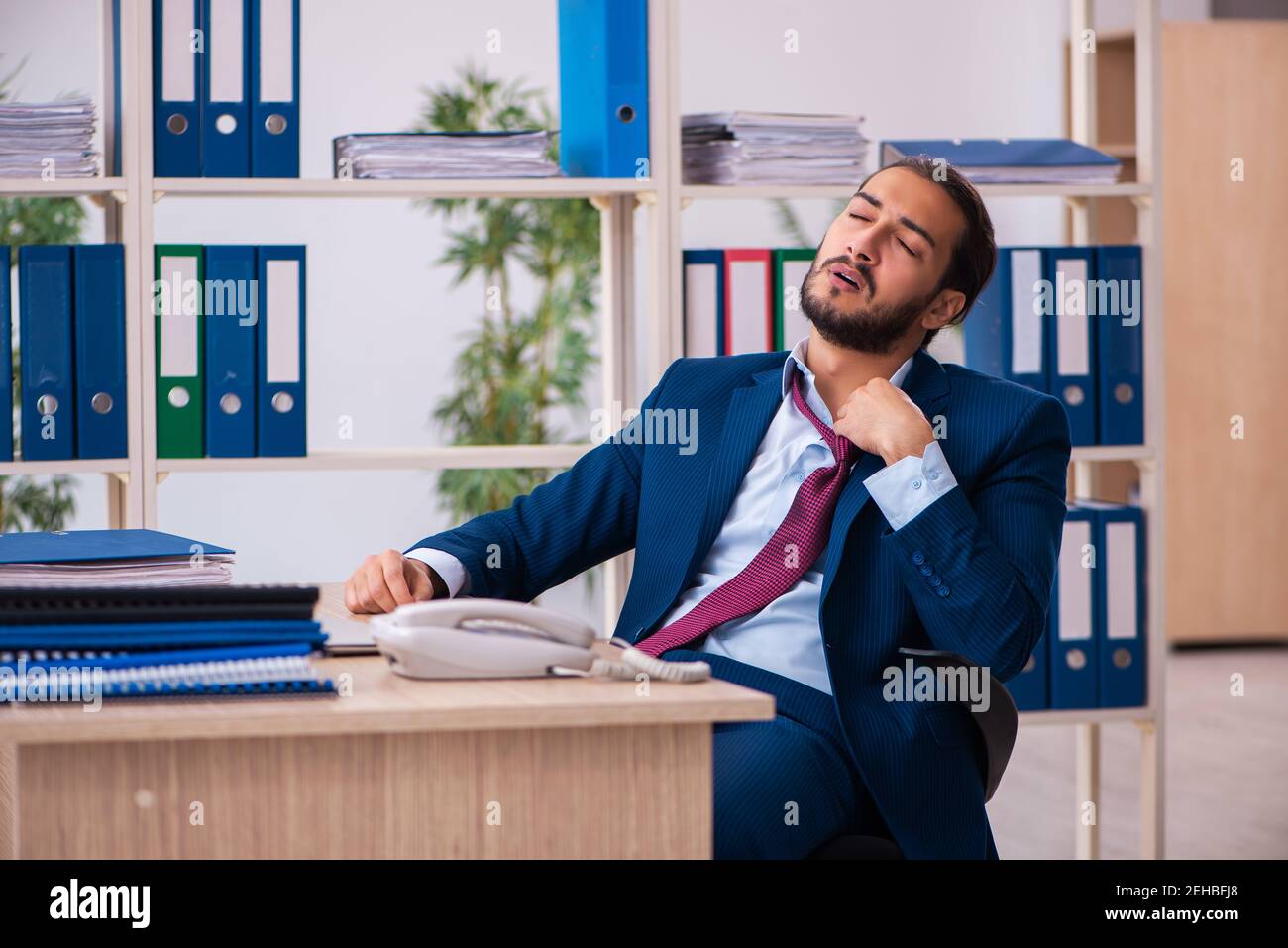 Young employee and too many work in the office Stock Photo - Alamy
