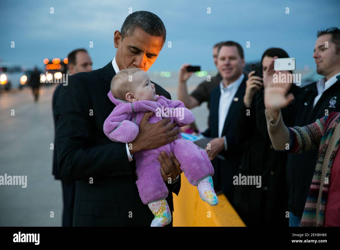 President Barack Obama kisses a baby on the tarmac following his ...
