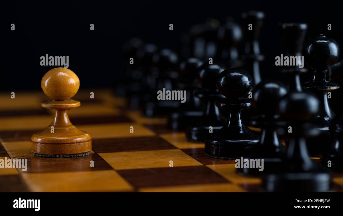 One white pawn against an army of black pieces on a chessboard Stock ...