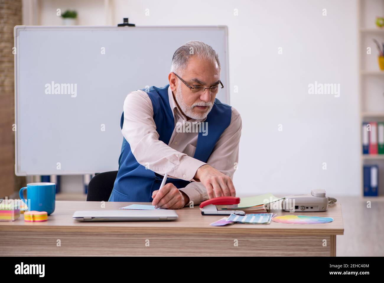 Aged male designer working in the office Stock Photo - Alamy