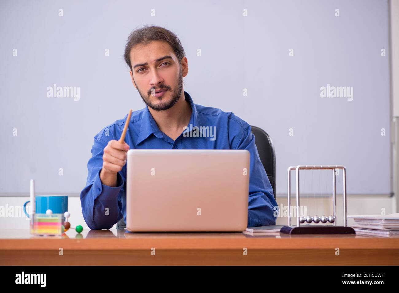 Young teacher physicist sitting in the classroom Stock Photo - Alamy