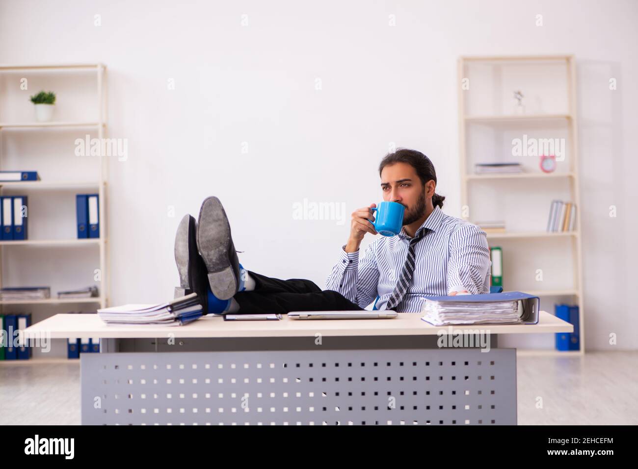 Young employee drinking coffee during break Stock Photo - Alamy