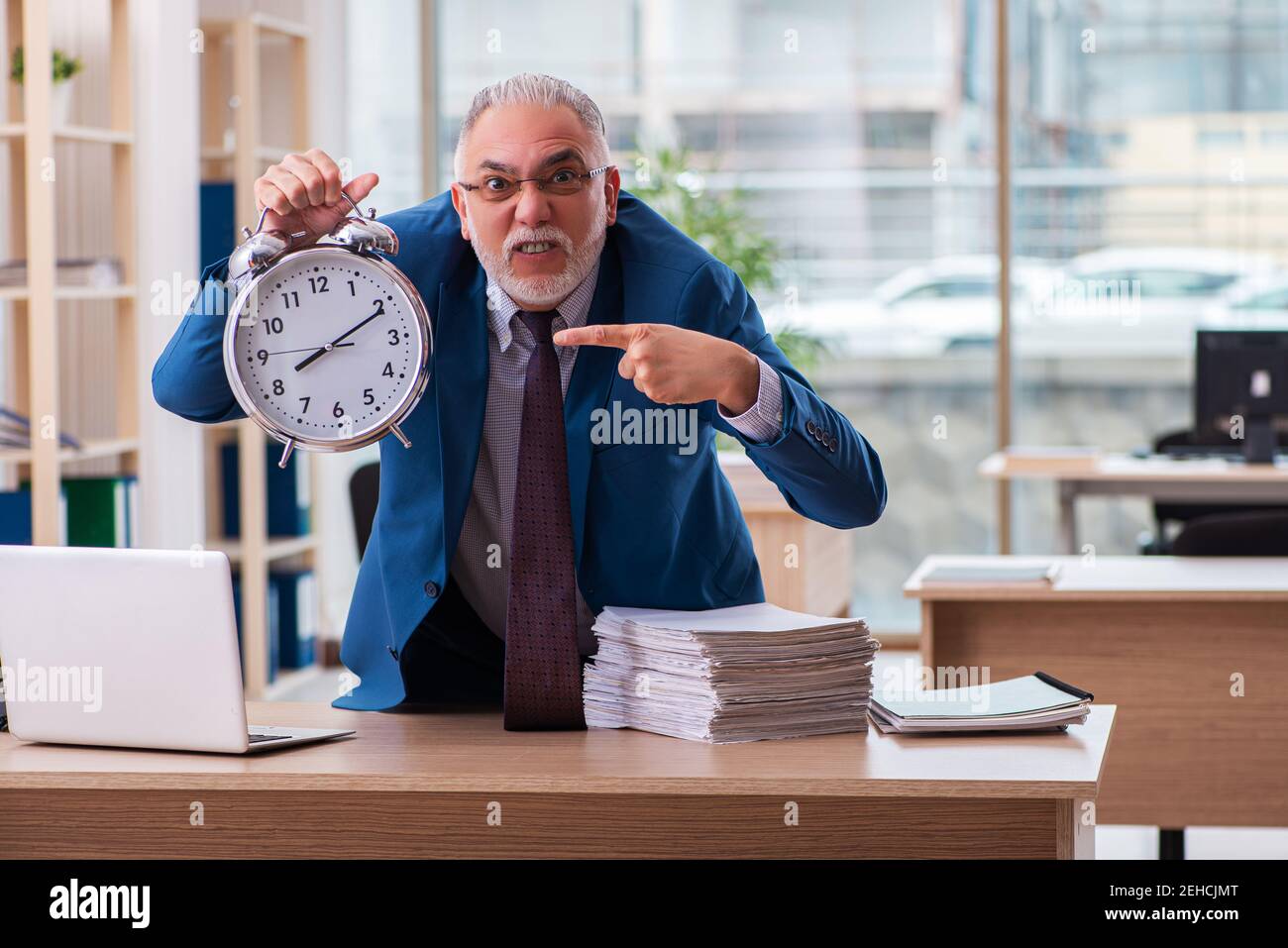 Old boss employee in time management concept Stock Photo - Alamy
