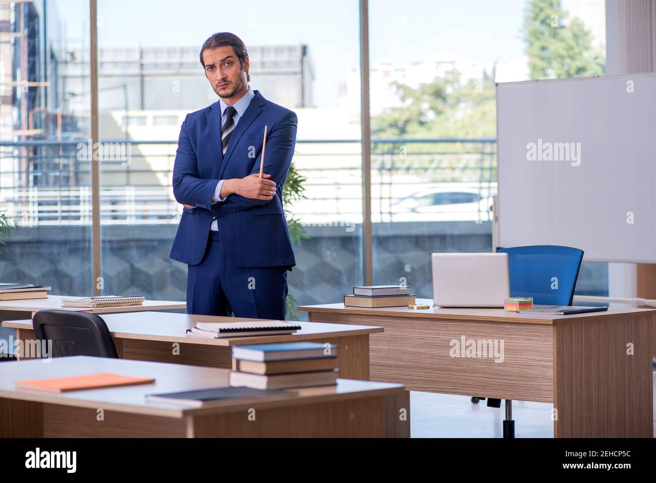 Young teacher in suit in the classroom Stock Photo - Alamy