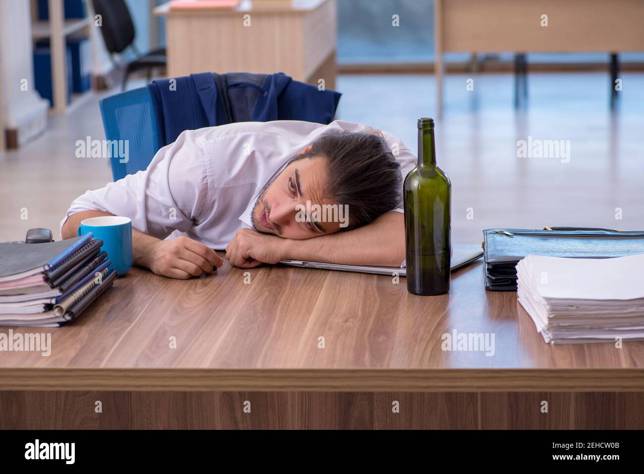 Young alcohol addicted employee working in the office Stock Photo - Alamy