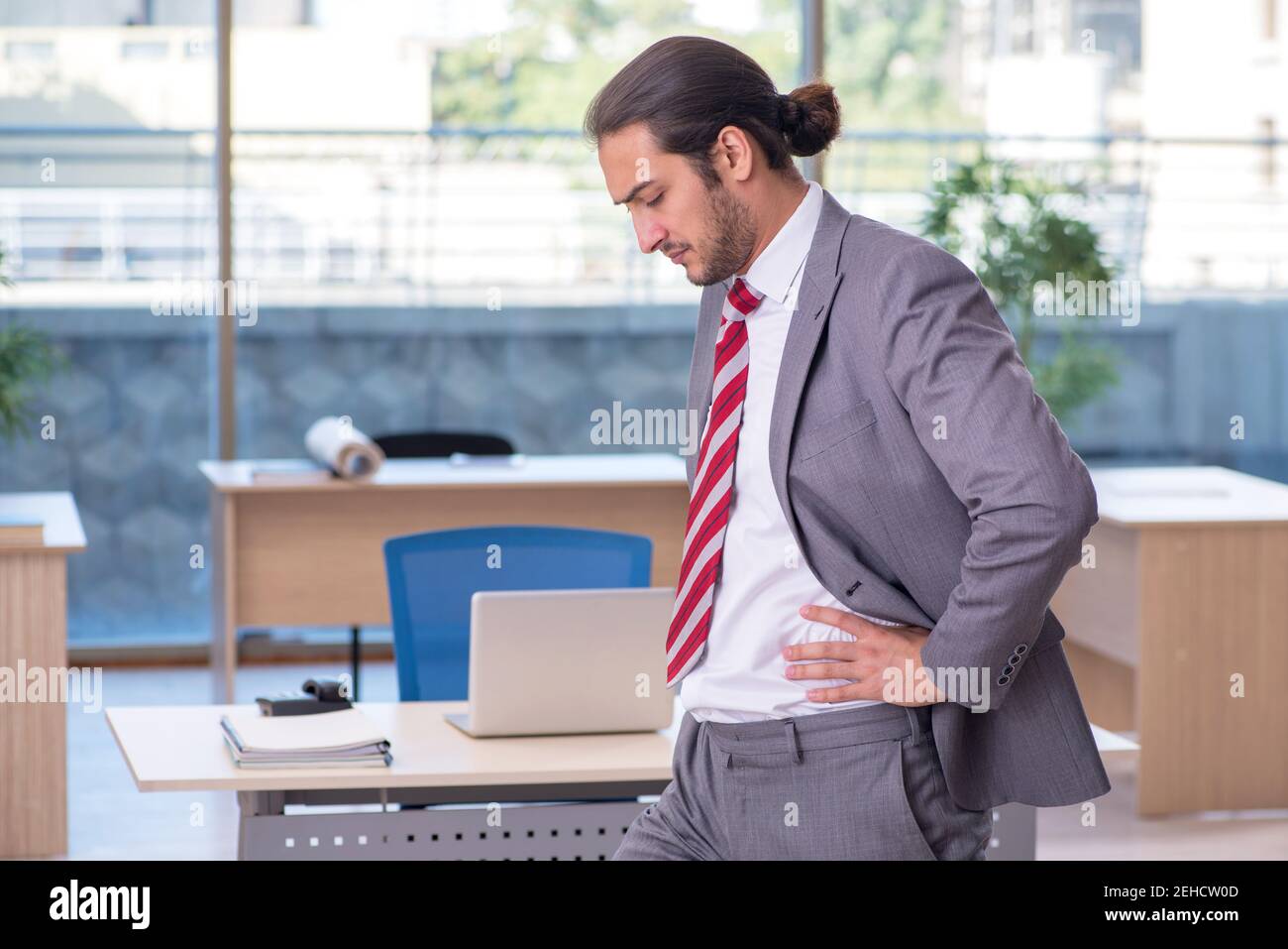 Young employee doing sport exercises at workplace Stock Photo - Alamy