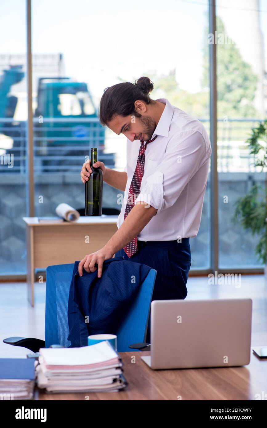 Young alcohol addicted employee working in the office Stock Photo - Alamy