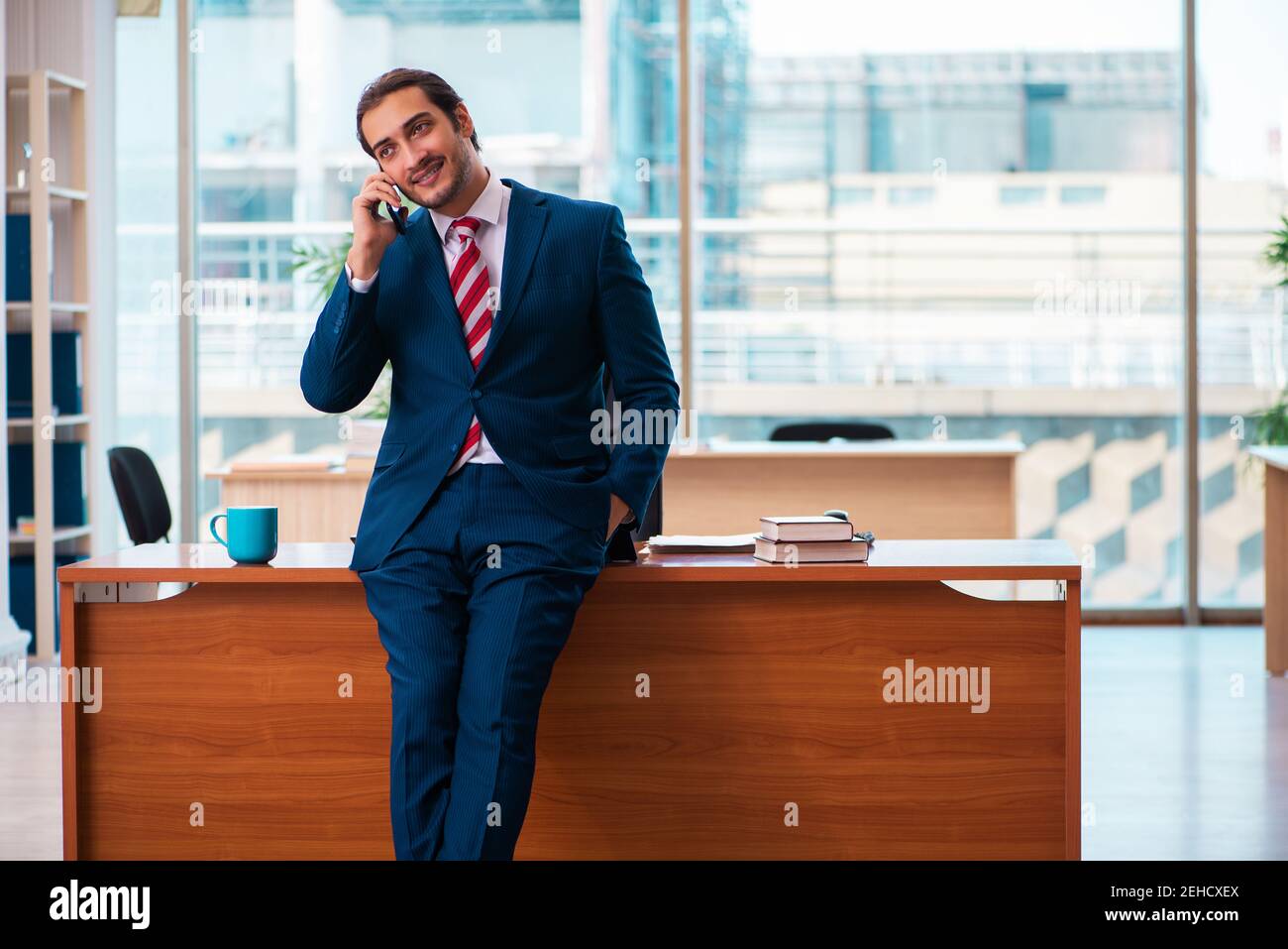 Young attractive male employee working in the office Stock Photo - Alamy