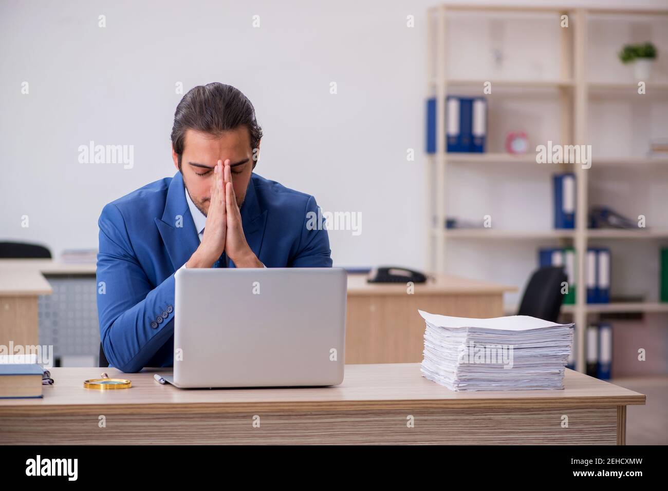 Young employee and too much work in the office Stock Photo - Alamy