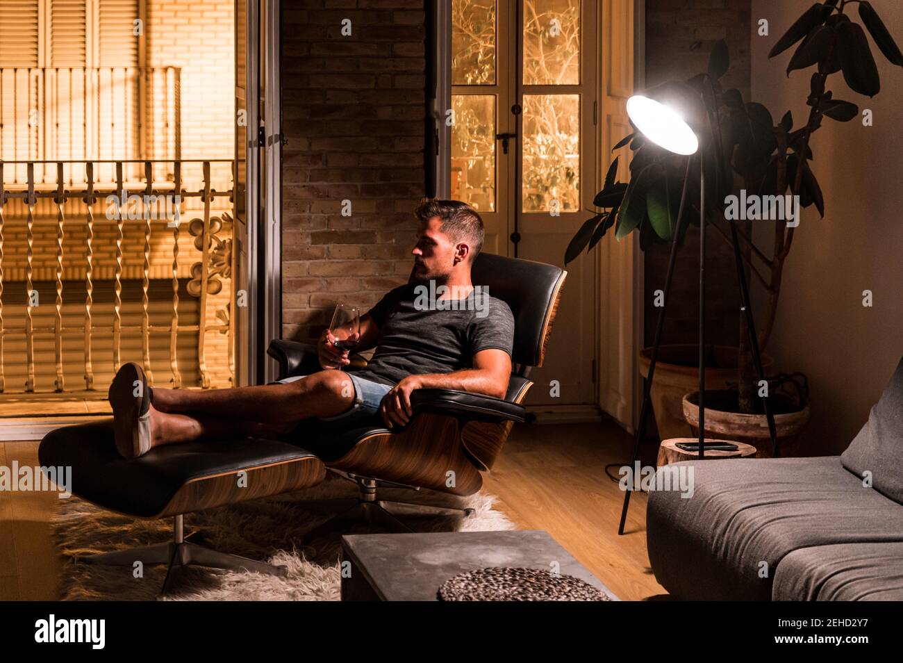 Side view of male in domestic outfit chilling in comfortable armchair ...