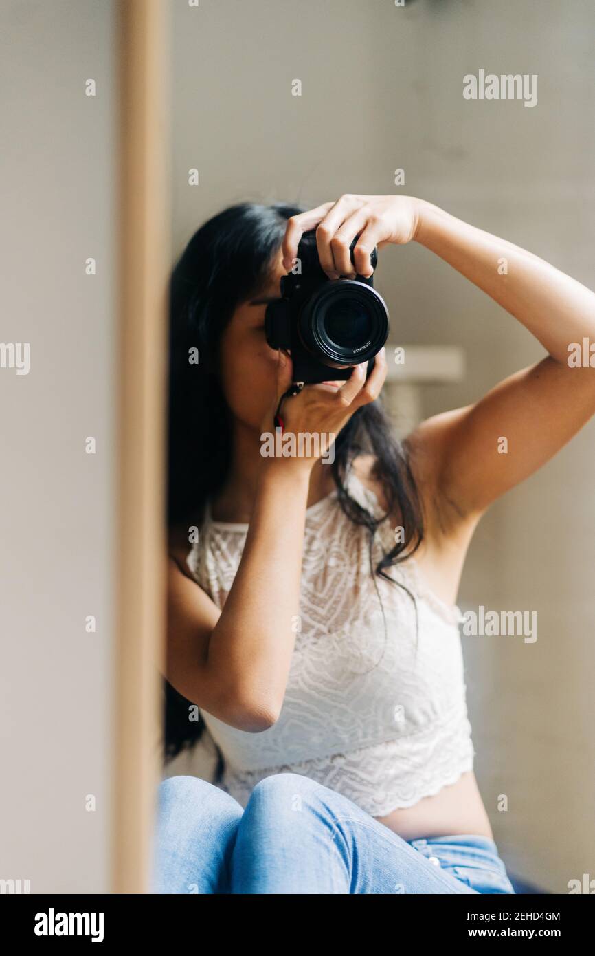 Long-haired brunette Woman looking in the mirror Stock Photo - Alamy