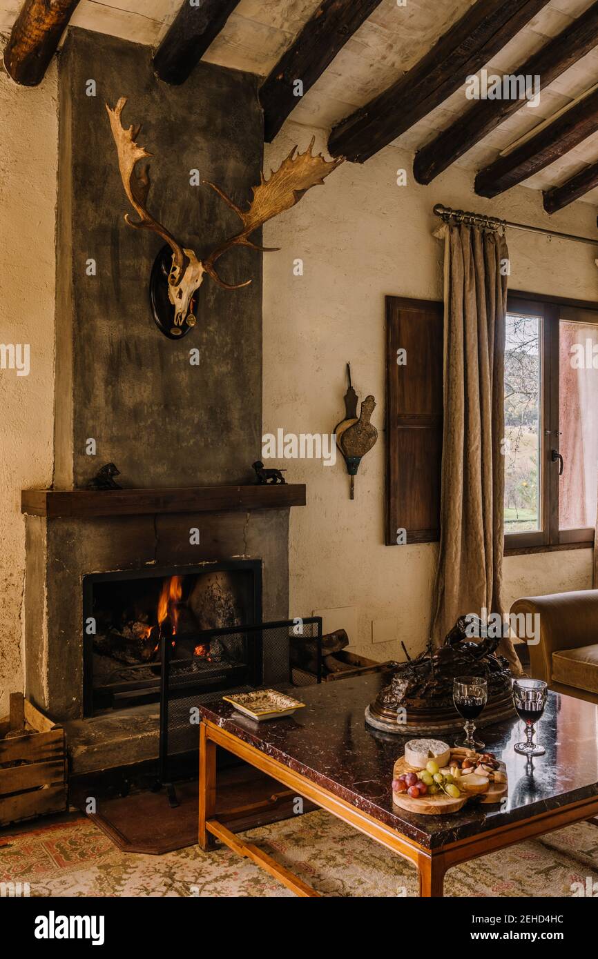 Interior of rustic hinting house with fireplace and horns of deer ...