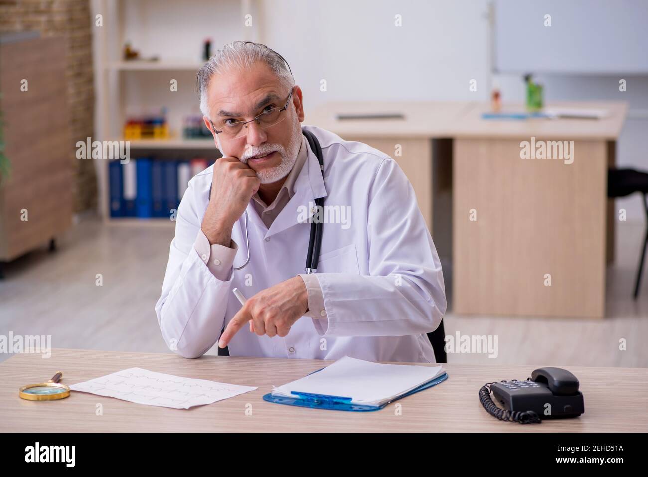 Old doctor cardiologist working in the clinic Stock Photo - Alamy