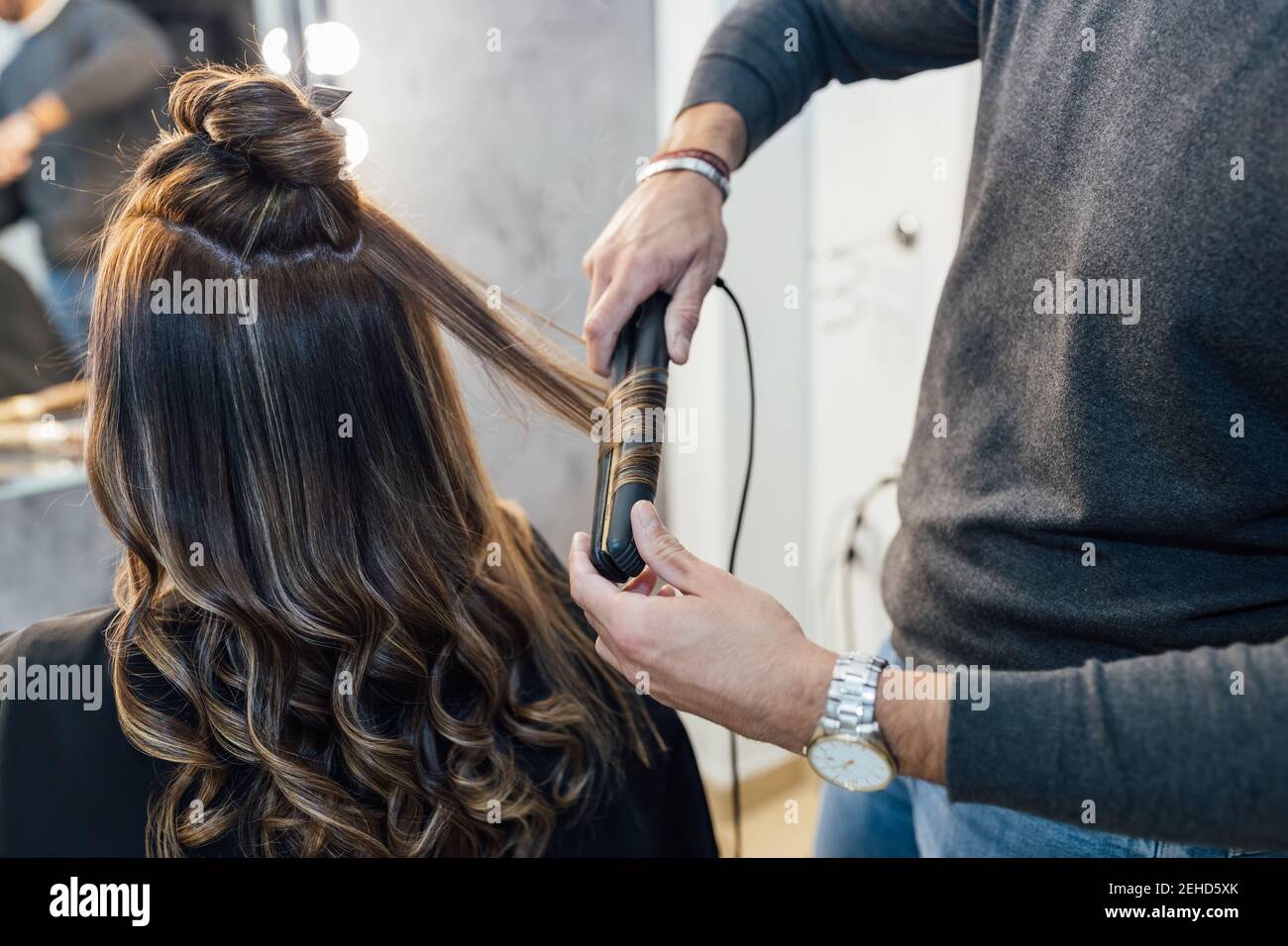 Crop unrecognizable male stylist in casual clothes using hair ...