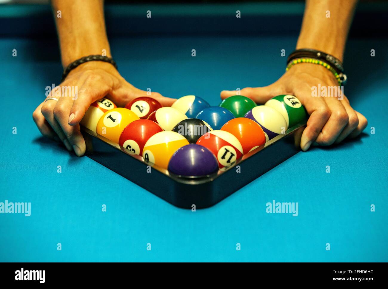 Crop male with curly hair making pyramid of balls for starting play ...