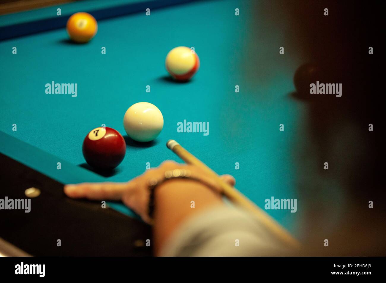 Crop focused bearded male hitting ball with cue while playing game in ...