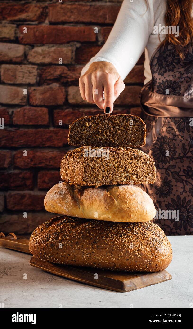Crop anonymous female baker demonstrating soft fresh bread with crunchy ...