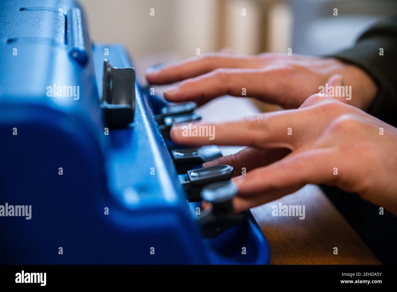 Crop anonymous visually impaired male typing on typewriter with tactile ...